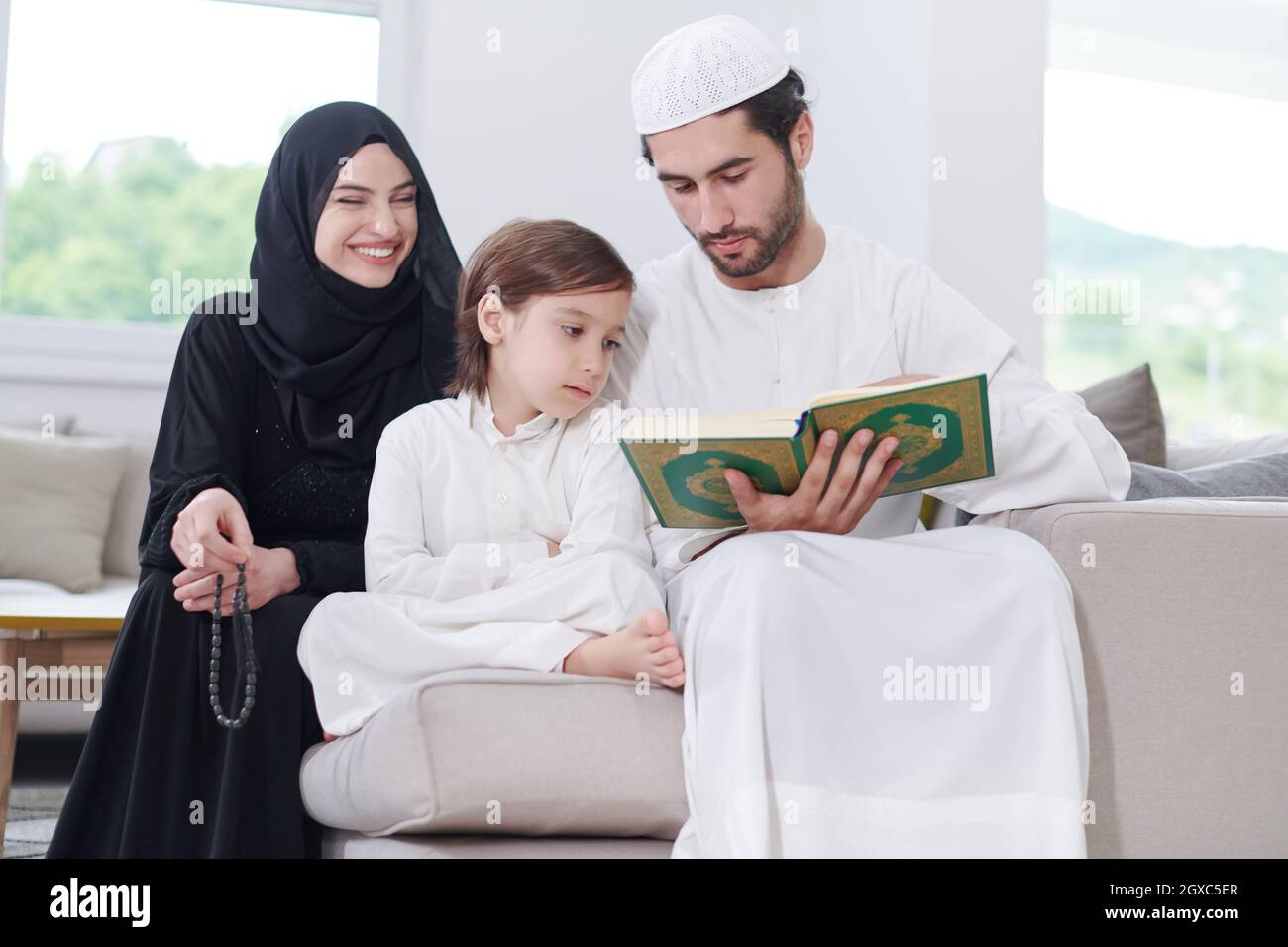 Traditional muslim family parents with children reading Quran and ...