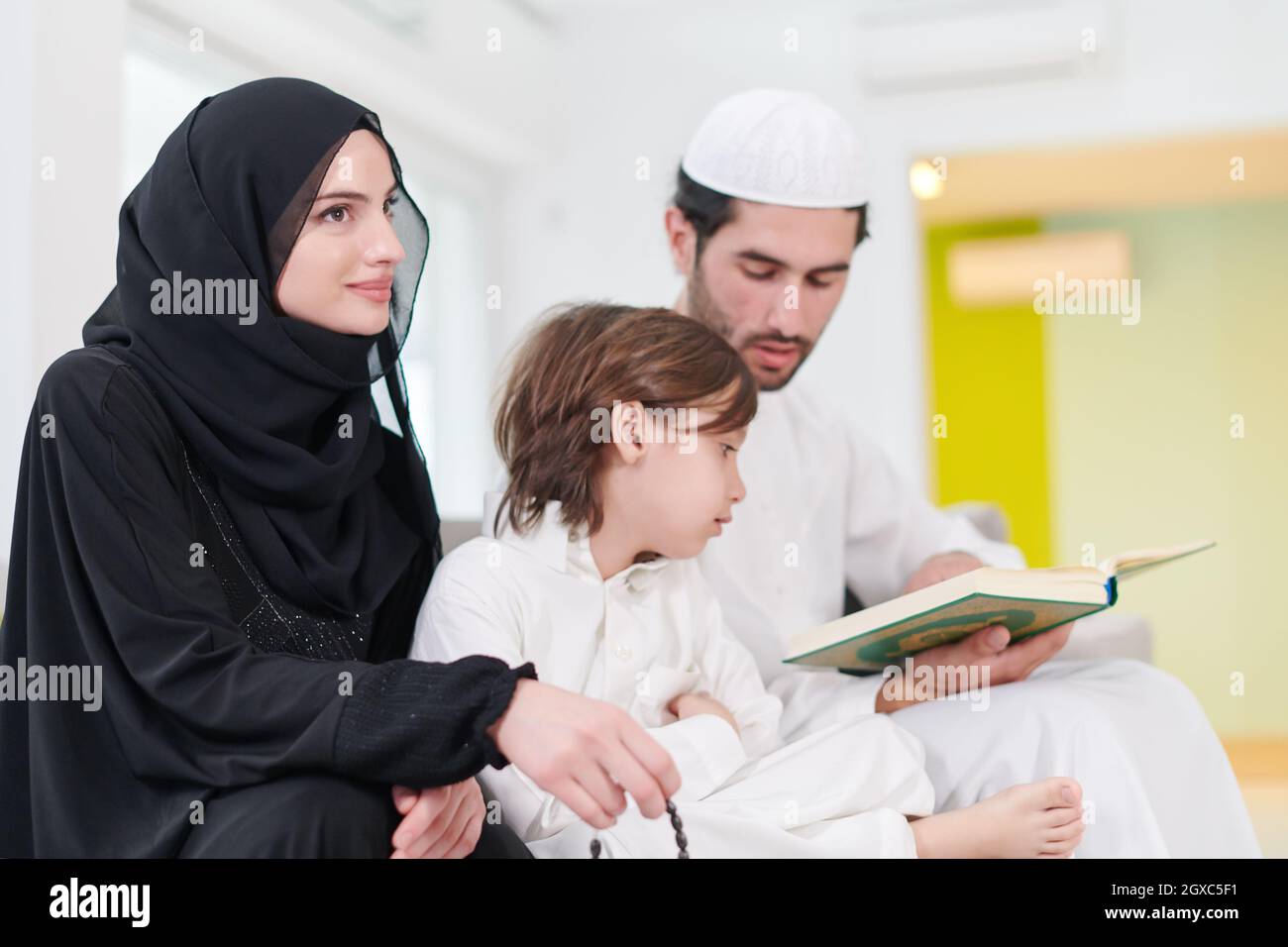 Traditional muslim family parents with children reading Quran and ...