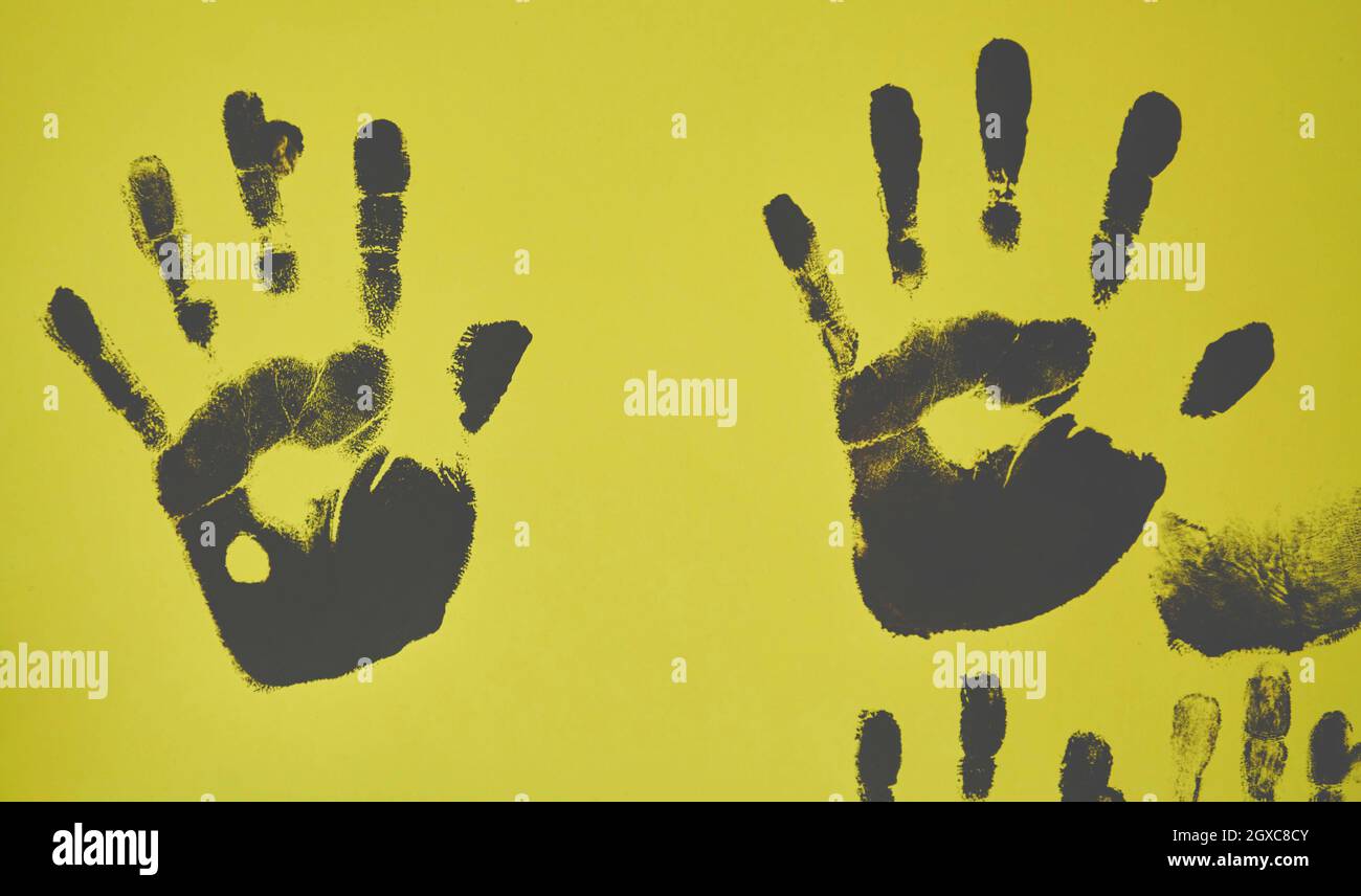 creative children black handprints painting on yellow paper Stock Photo ...