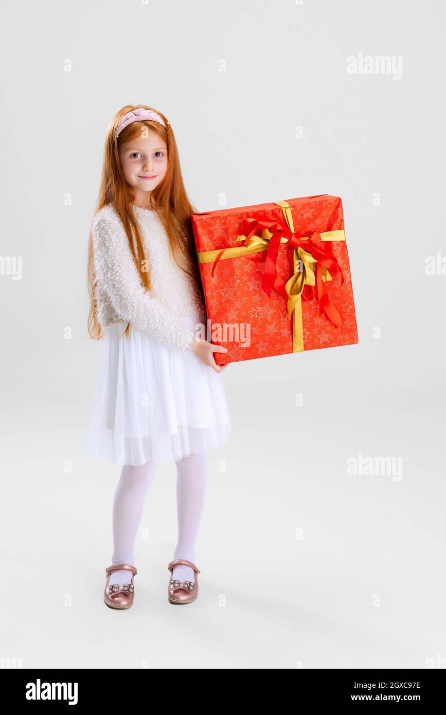 Full-length portrait of happy and delightful child, girl holding big ...