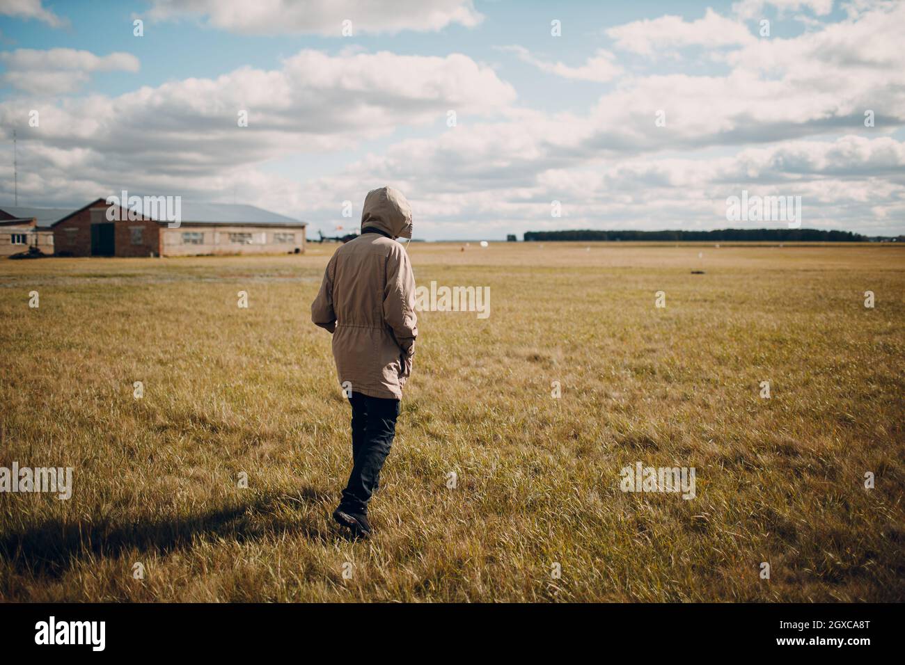 Man walking in grass field in autumn dressed Stock Photo - Alamy