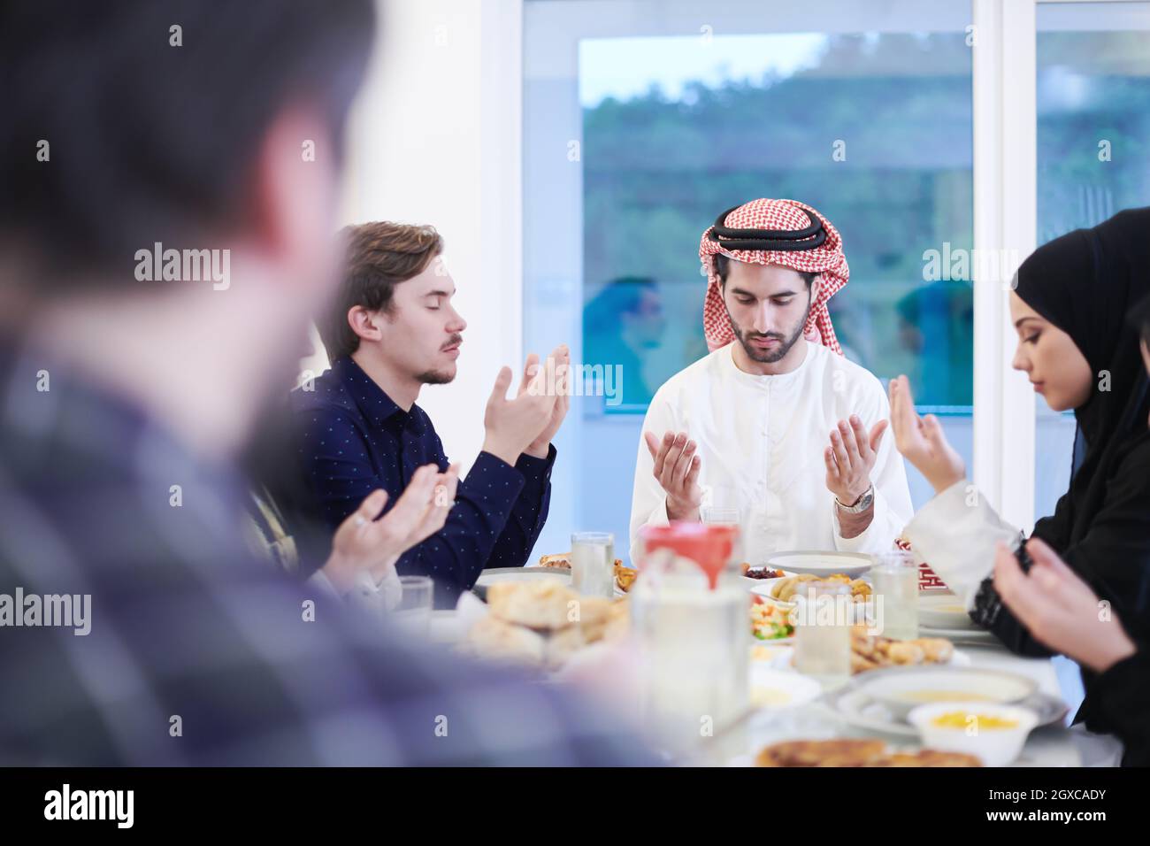 Eid Mubarak Muslim people praying before iftar dinner. Eating ...