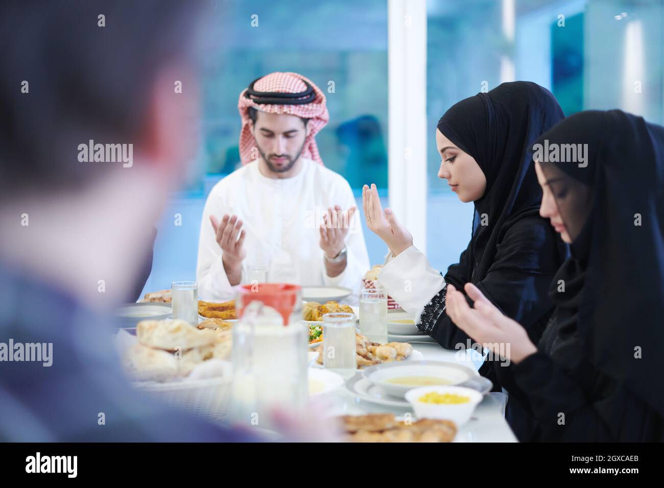 Eid Mubarak Muslim people praying before iftar dinner. Eating ...