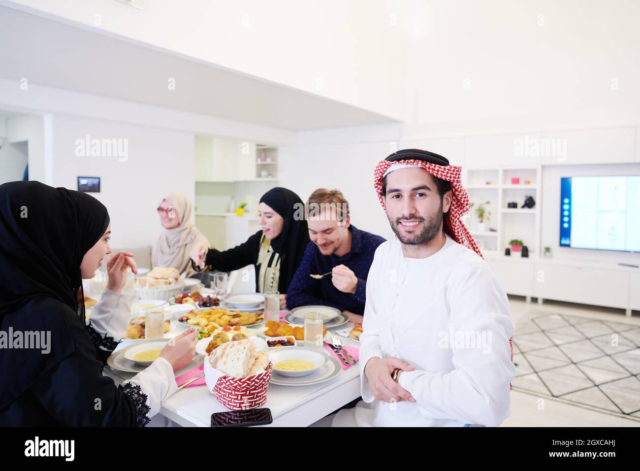 young arabian man having Iftar dinner with muslim family Eating ...