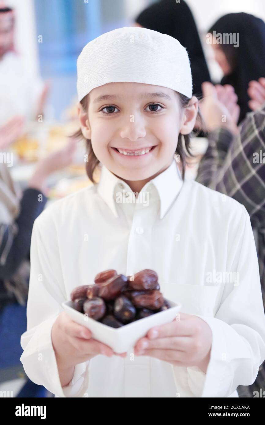Eid Mubarak Muslim family having Iftar dinner little boy holding a ...