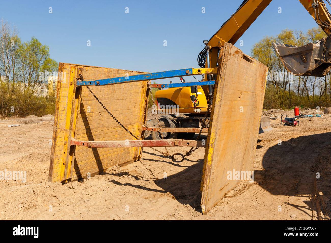 Installation of metal supports to protect the walls of the trench. The ...