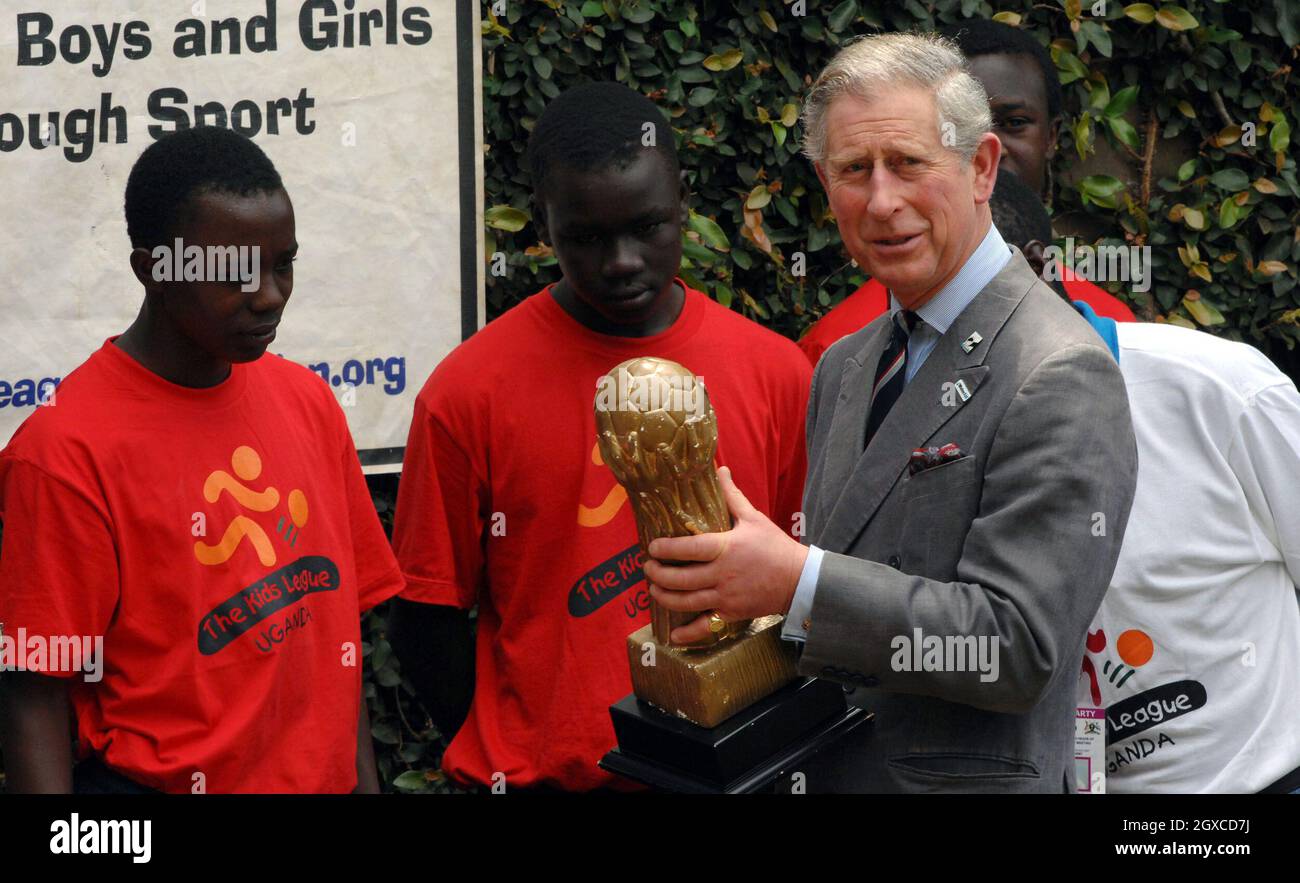 Prince Charles, Prince of Wales holds a trophy at the Kampala Kids ...