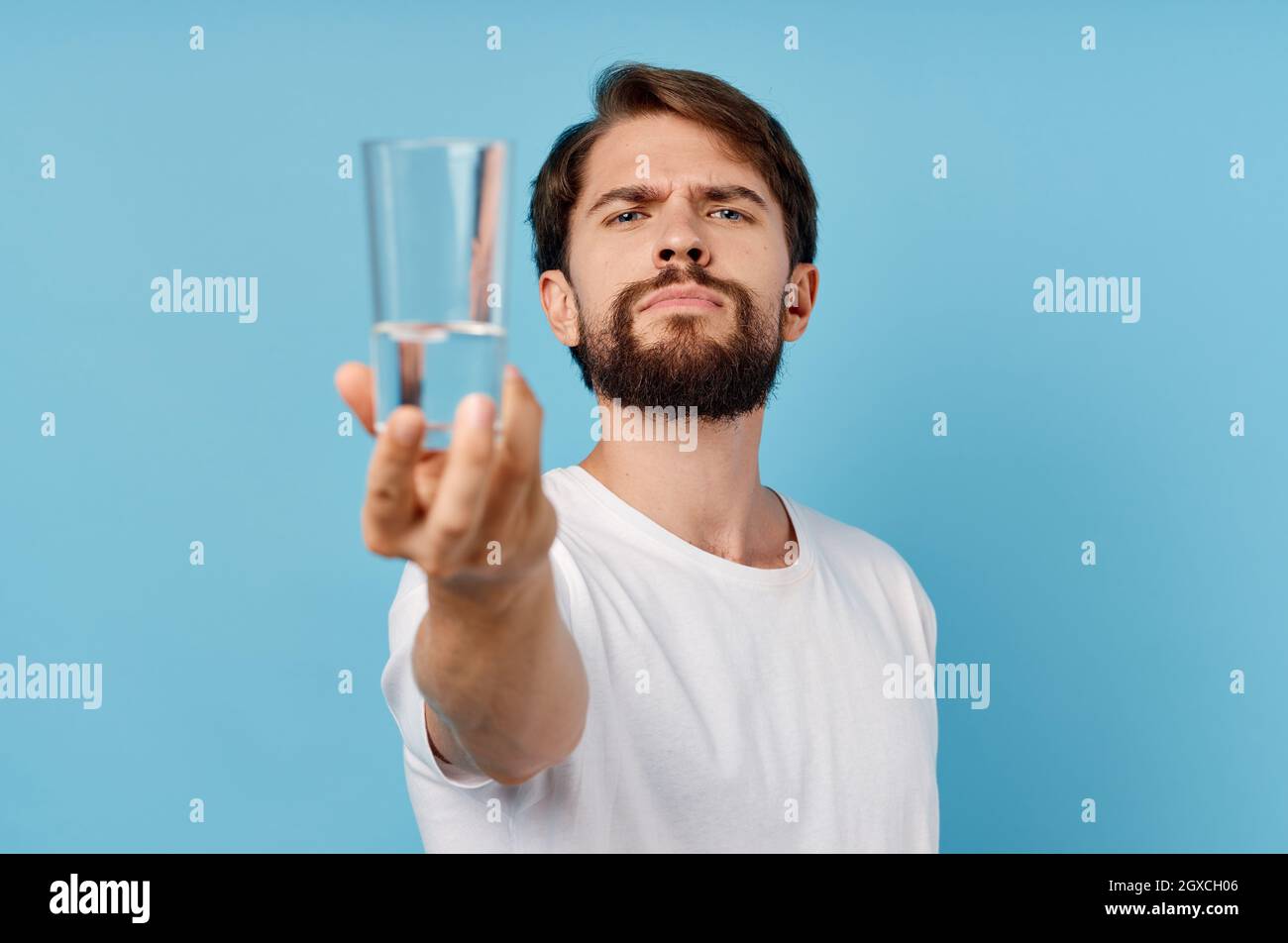 pretty man glass of water blue background Stock Photo - Alamy
