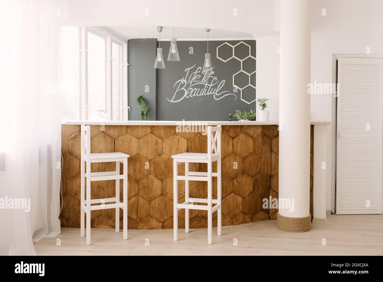 A stylish modern bar counter decorated with wooden tiles and two white ...