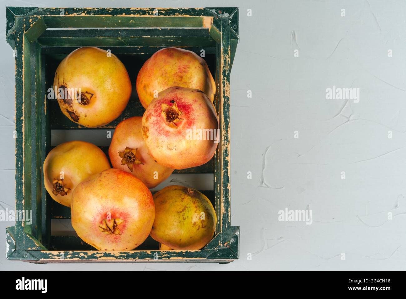 Fresh pomegranates in an old box on wooden background Stock Photo - Alamy