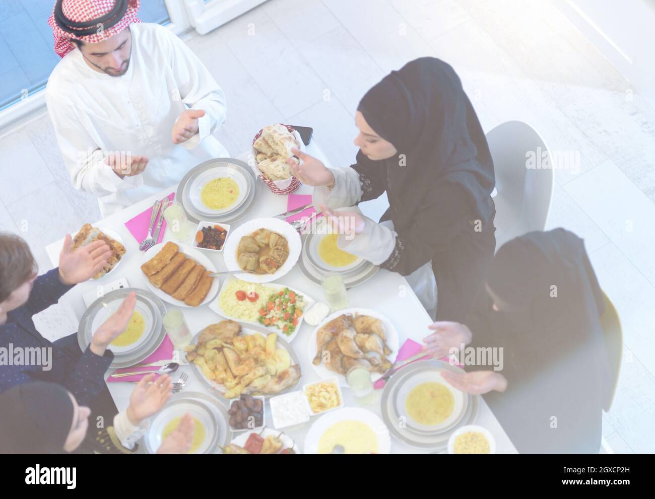 Eid Mubarak Muslim people praying before iftar dinner. Eating ...