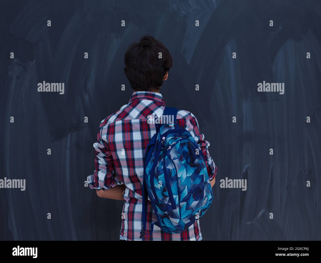 arab teenager with backpack wearing casual school look against black ...