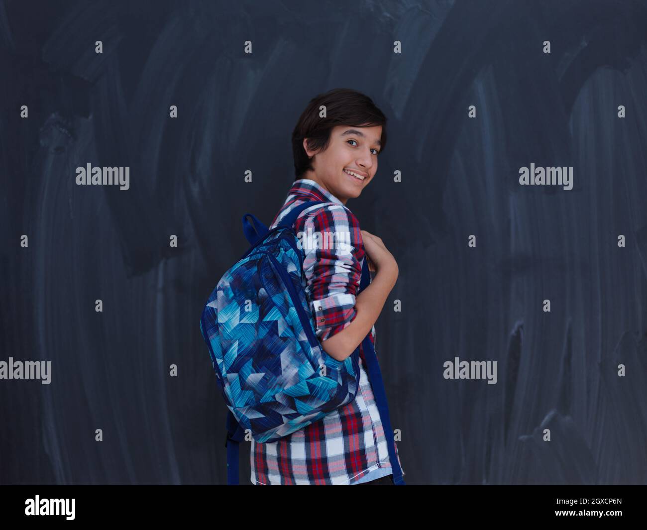 arab teenager with backpack wearing casual school look against black ...