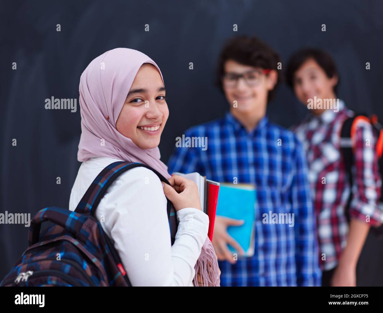 Arabic teenagers, students group portrait against black chalkboard ...