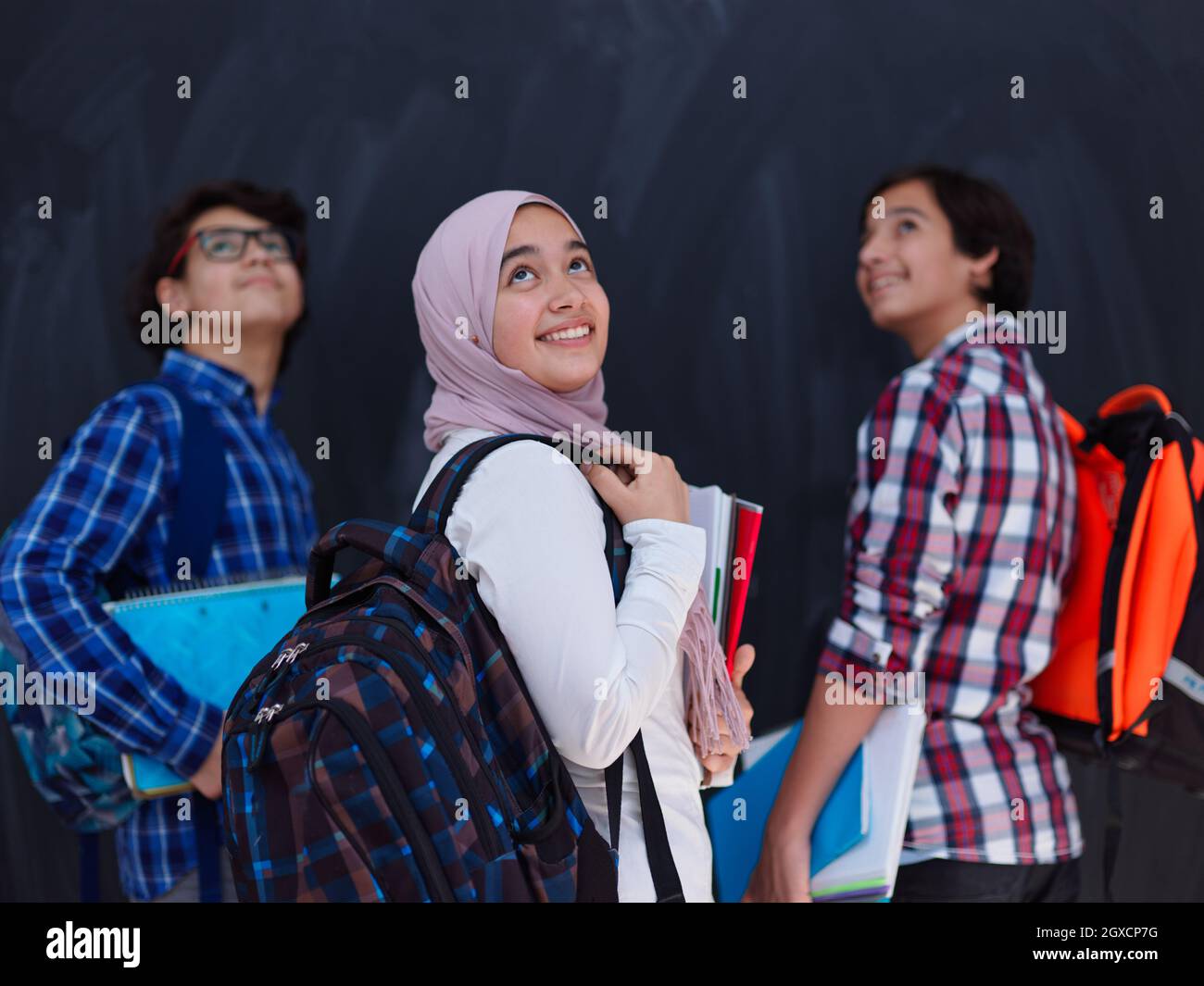 Arabic teenagers, students group portrait against black chalkboard ...