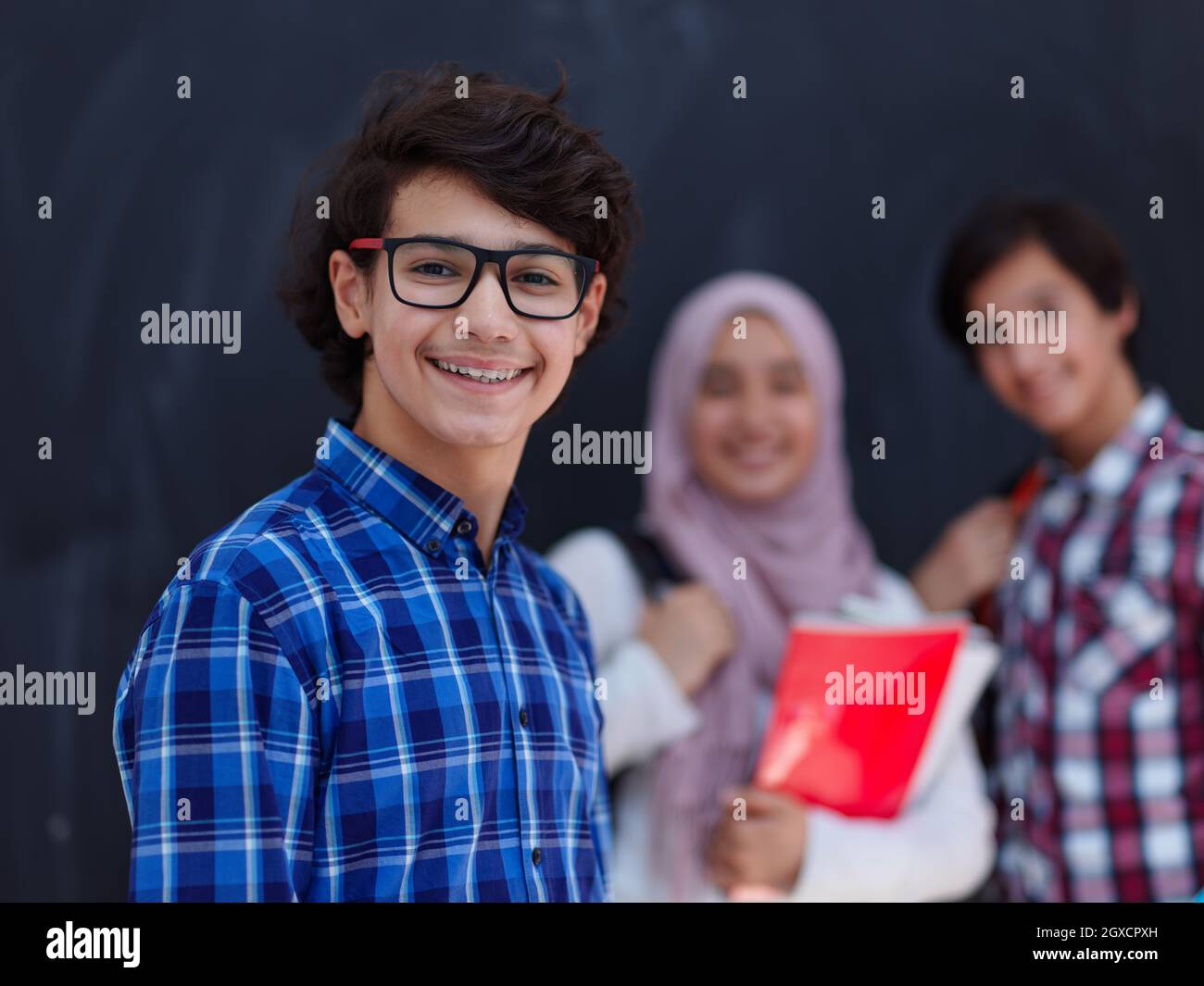 Arabic teenagers, students group portrait against black chalkboard ...