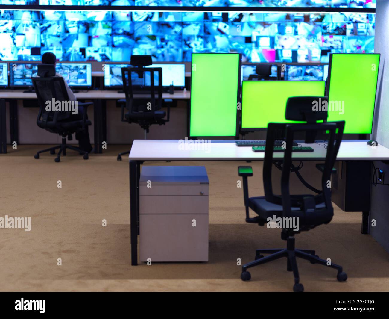 interior of big modern security system control room with blank green ...