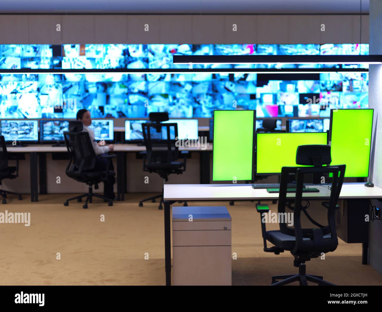 interior of big modern security system control room with blank green ...