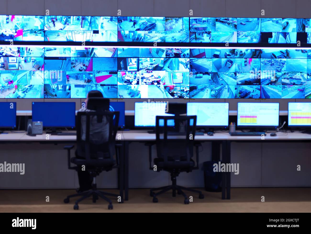 Female security operator working in a data system control room offices ...