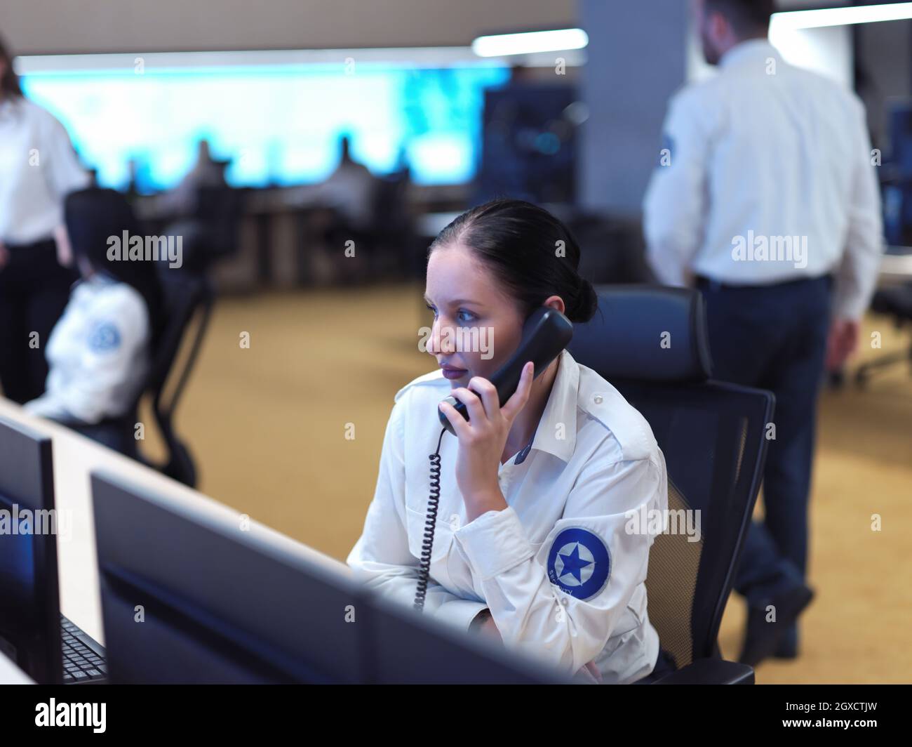 Female security guard operator talking on the phone while working at ...