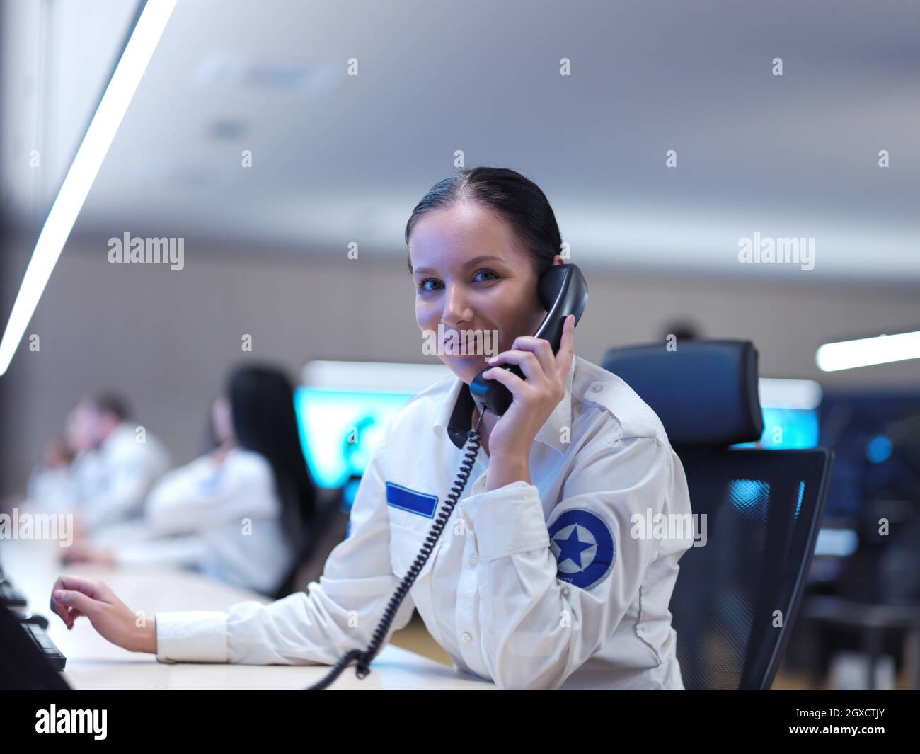 Female security guard operator talking on the phone while working at ...