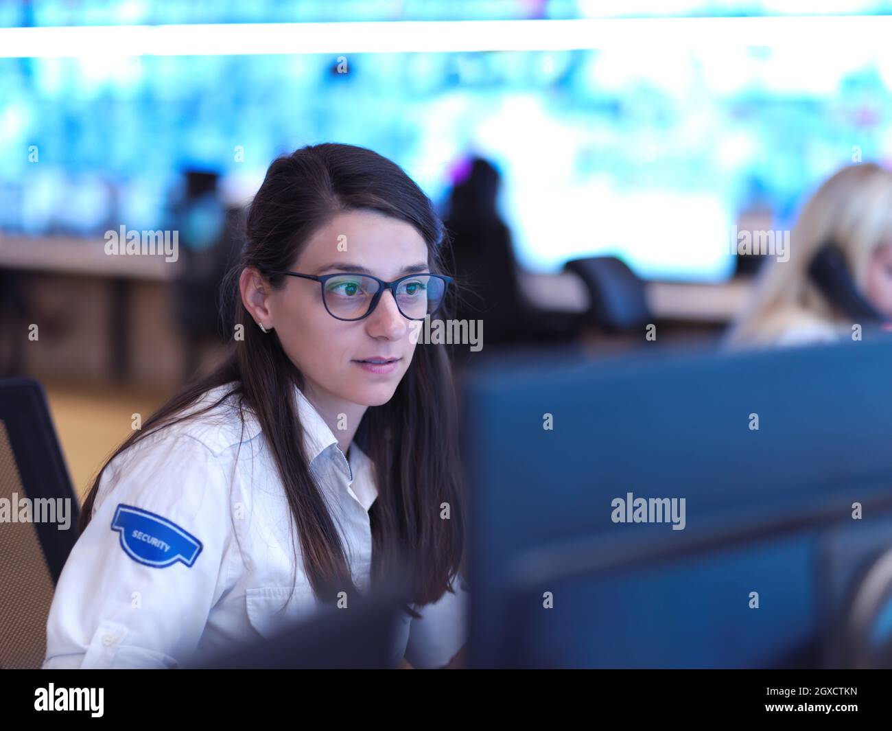 Female security operator working in a data system control room offices ...