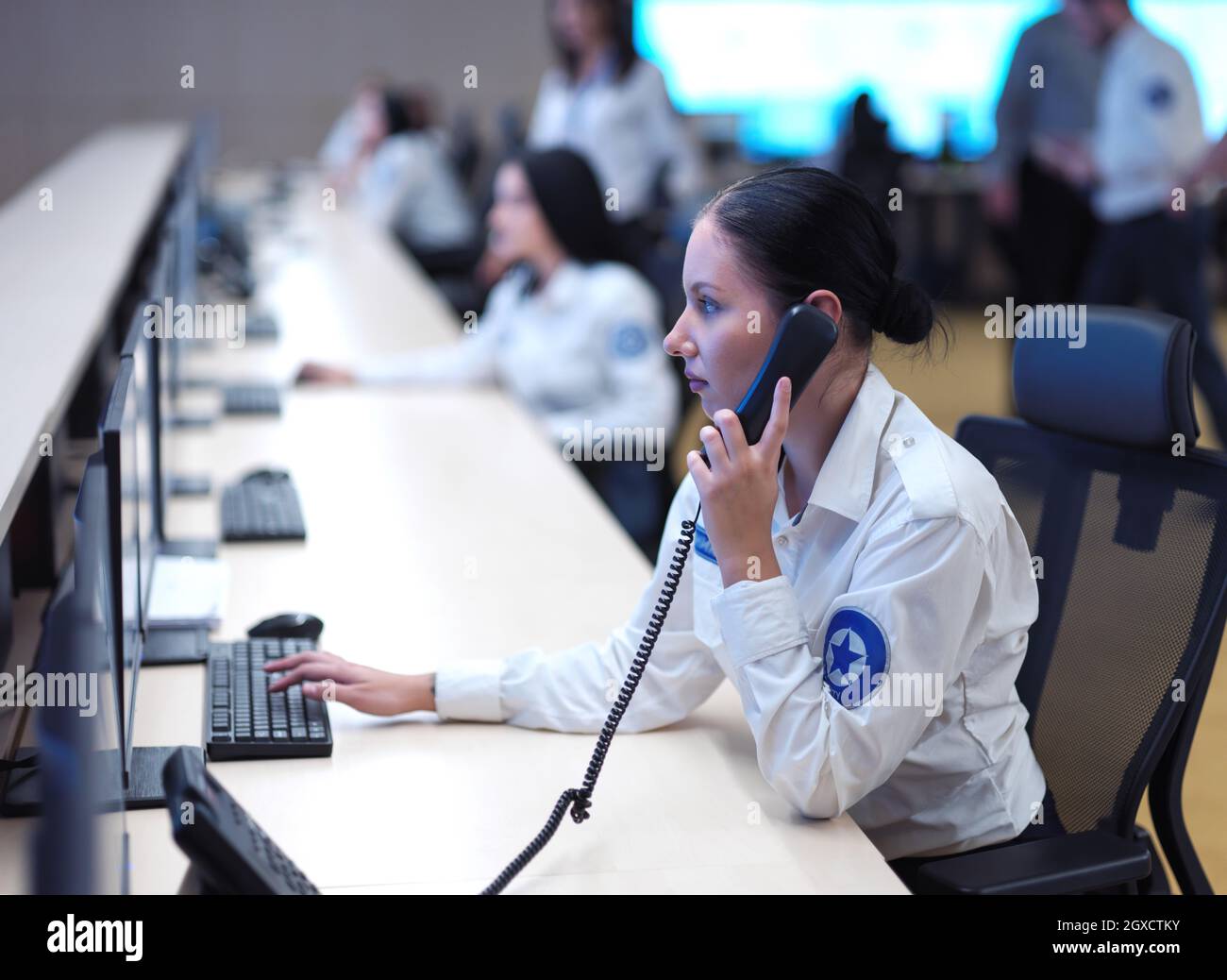 Female security guard operator talking on the phone while working at ...
