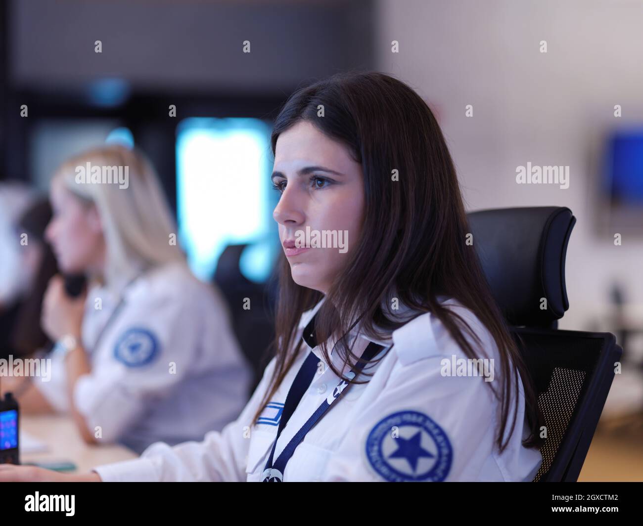 Female security operator working in a data system control room offices ...