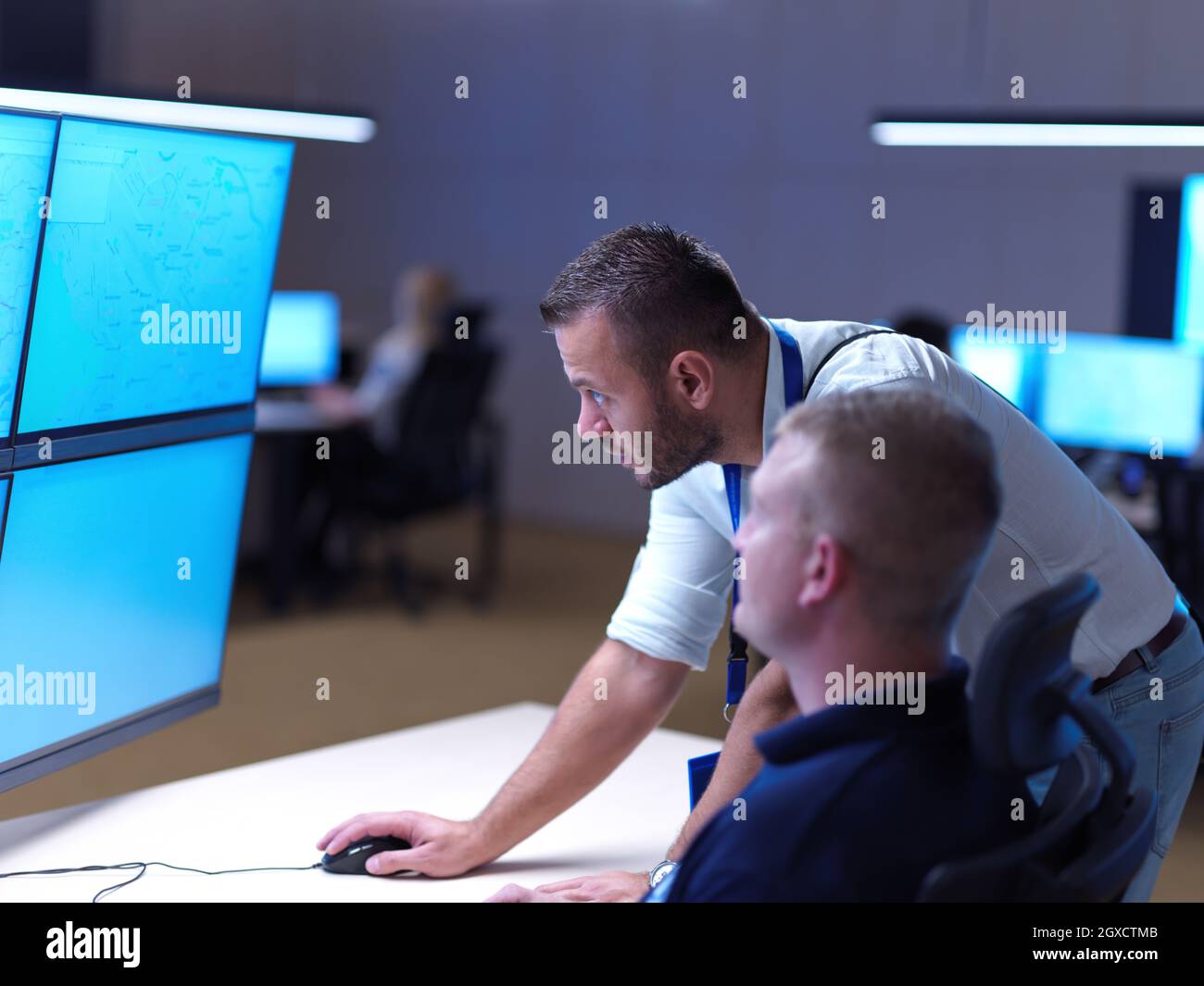 Male security operators working in a data system control room offices ...