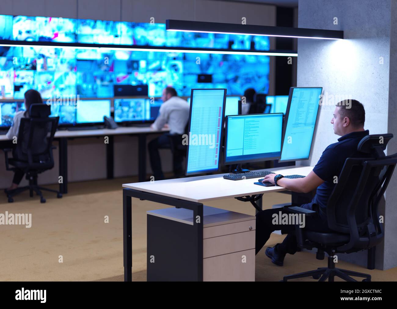 Male security operator working in a data system control room offices ...