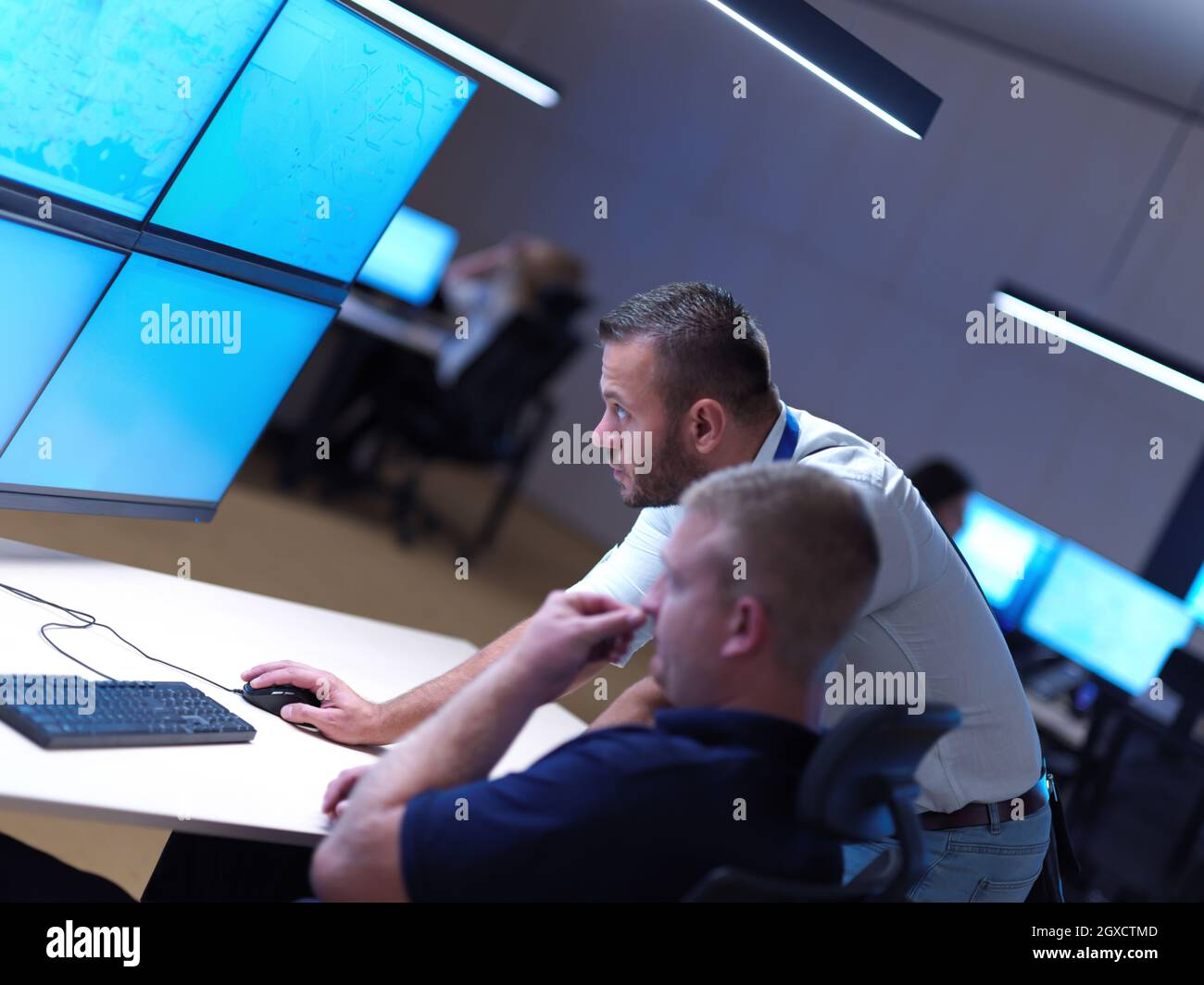 Male security operators working in a data system control room offices ...