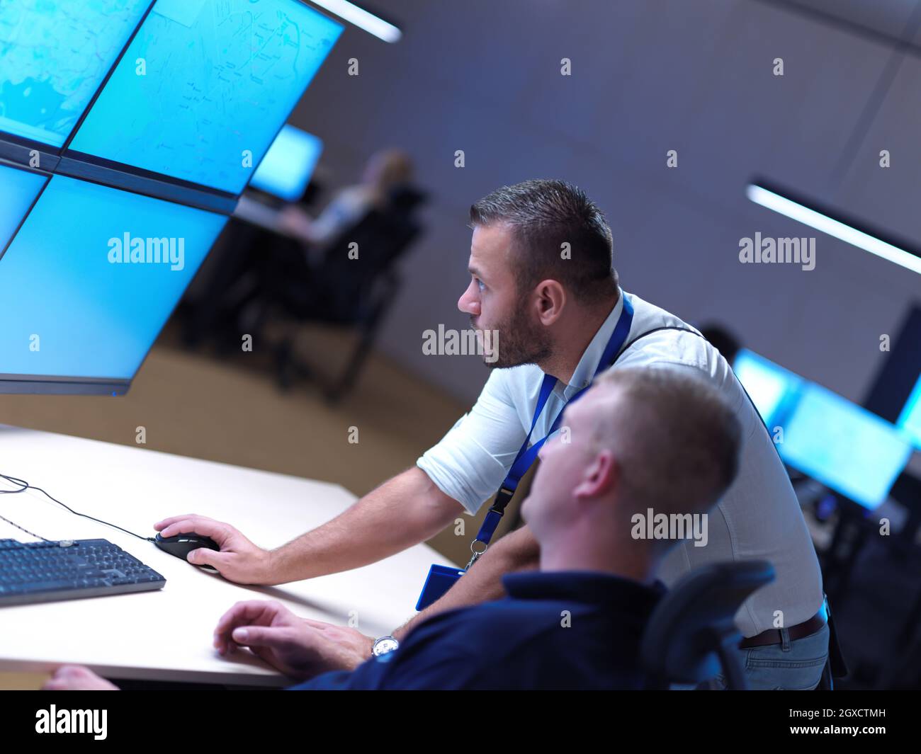 Male security operators working in a data system control room offices ...