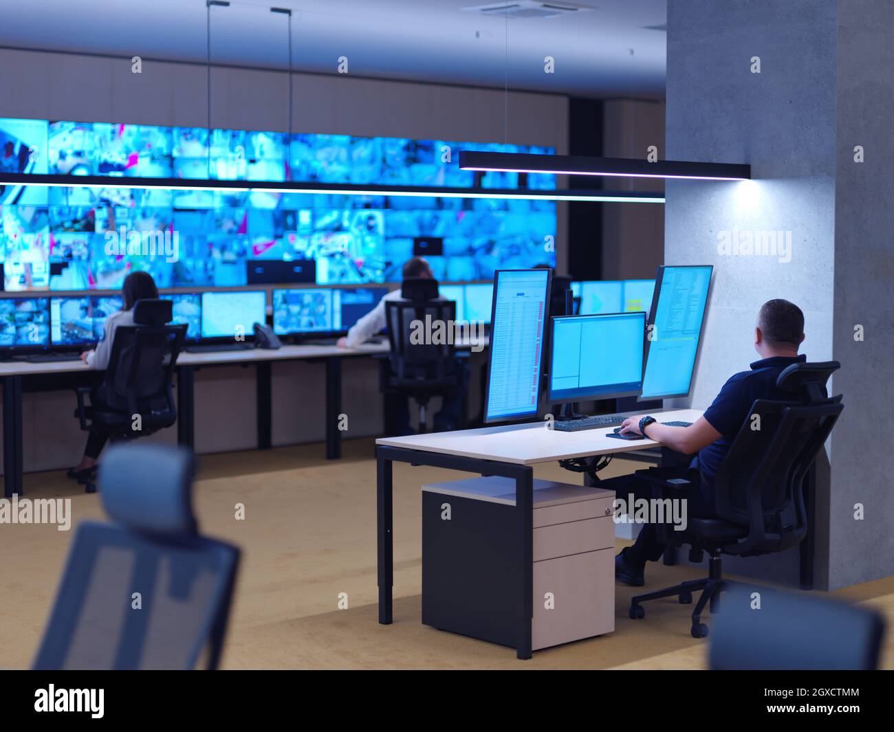 Male security operator working in a data system control room offices ...