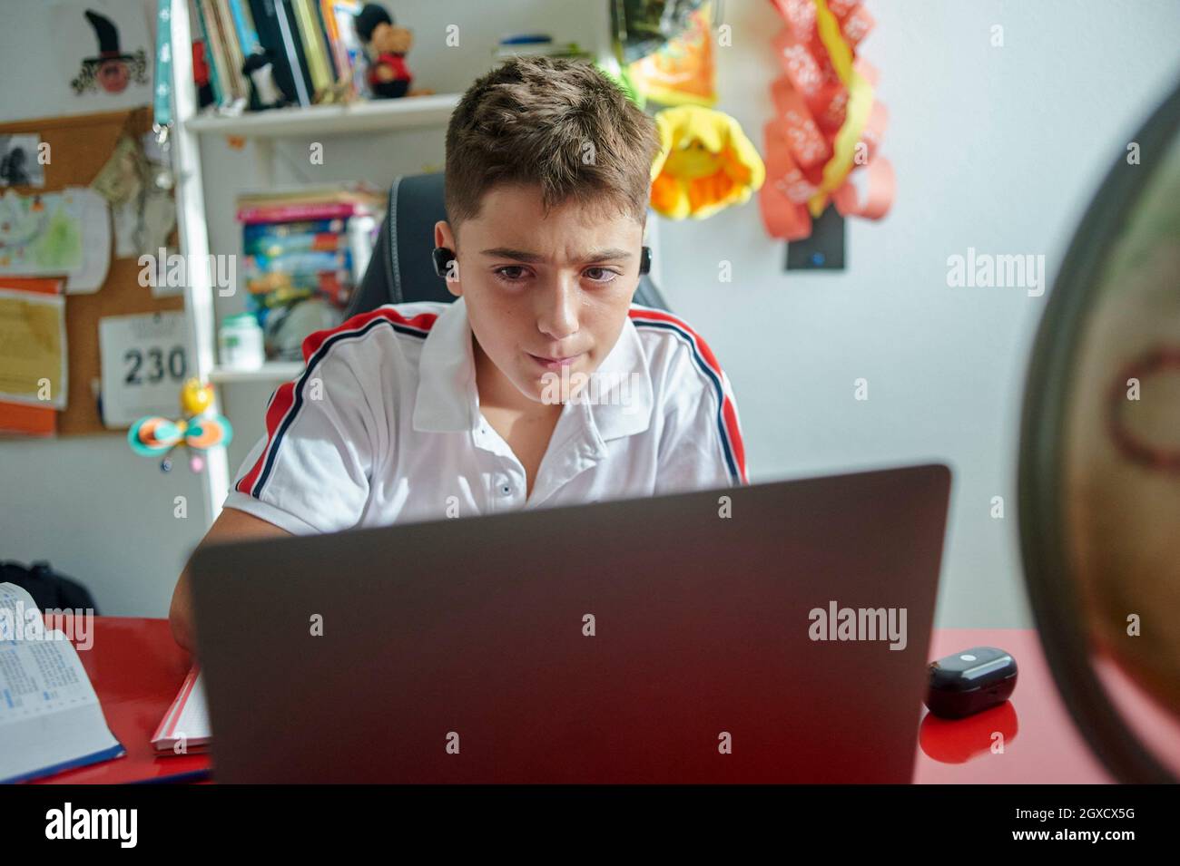 teenager teaching online classes and doing his homework in his study ...