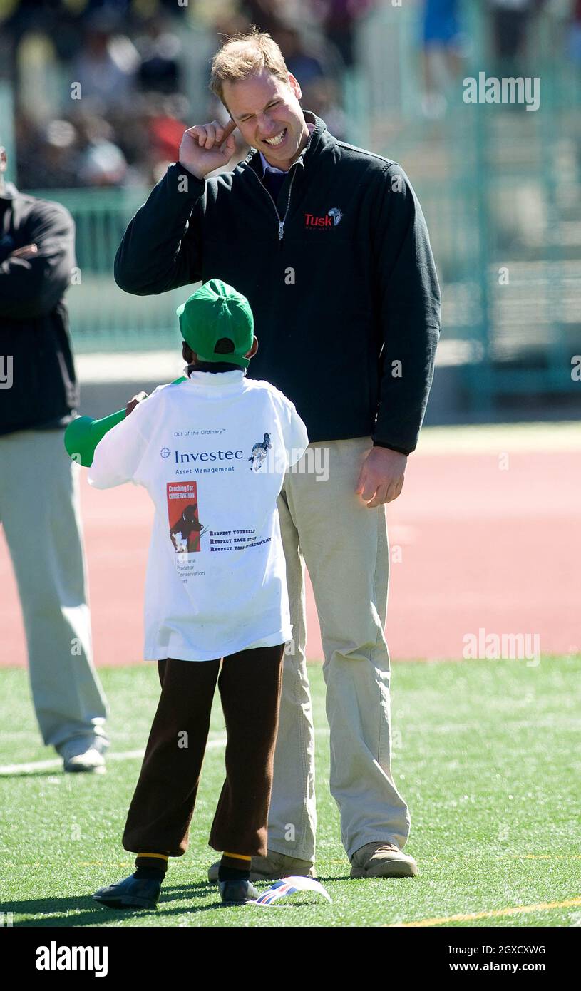 Prince William blocks his ears as a young boy blows the vuvuzela during ...
