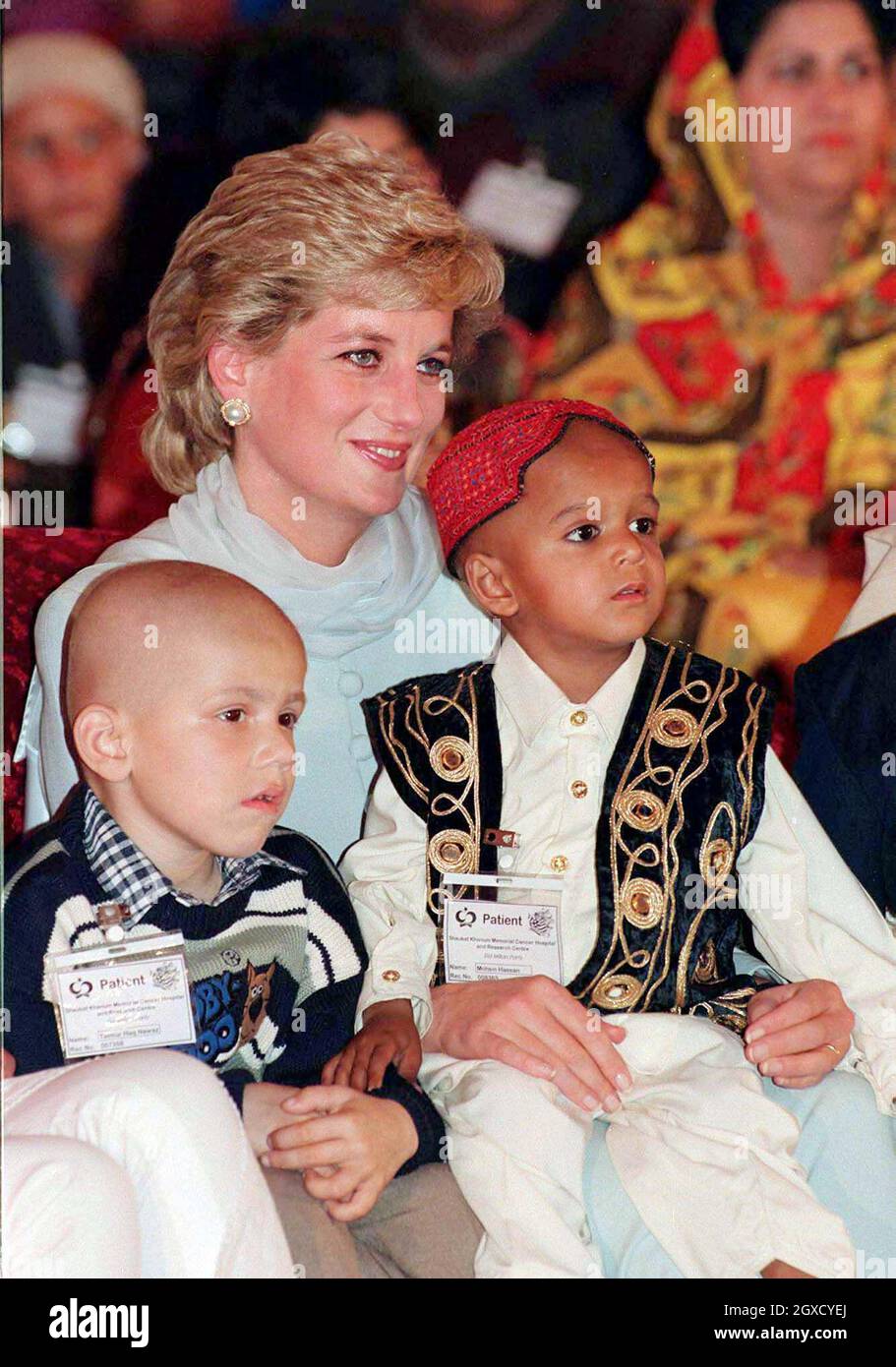 Diana, Princess of Wales, holds two young patients on her knees during ...