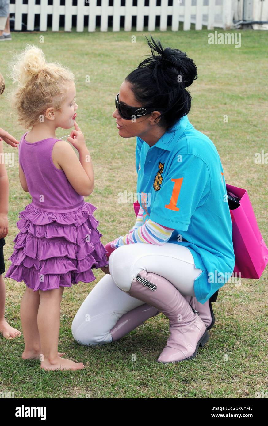 Katie Price bends to talk to her daughter Princess Tiaamii at the ...