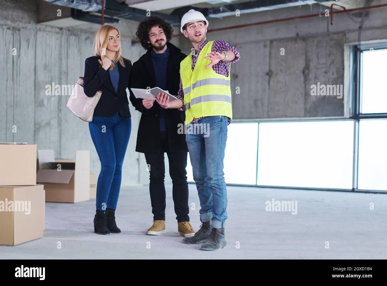 architect using tablet computer while showing house design plans to a ...