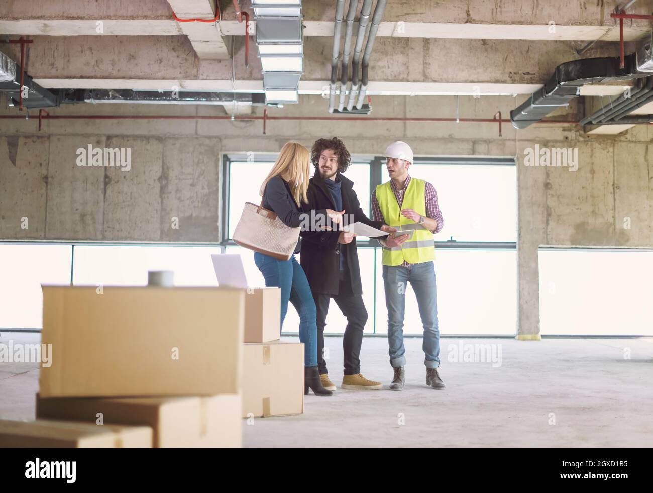 architect using tablet computer while showing house design plans to a ...