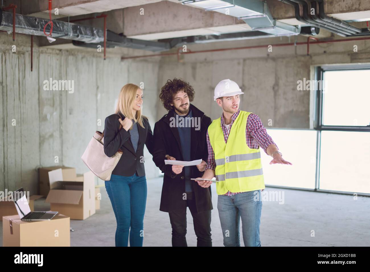 architect using tablet computer while showing house design plans to a ...