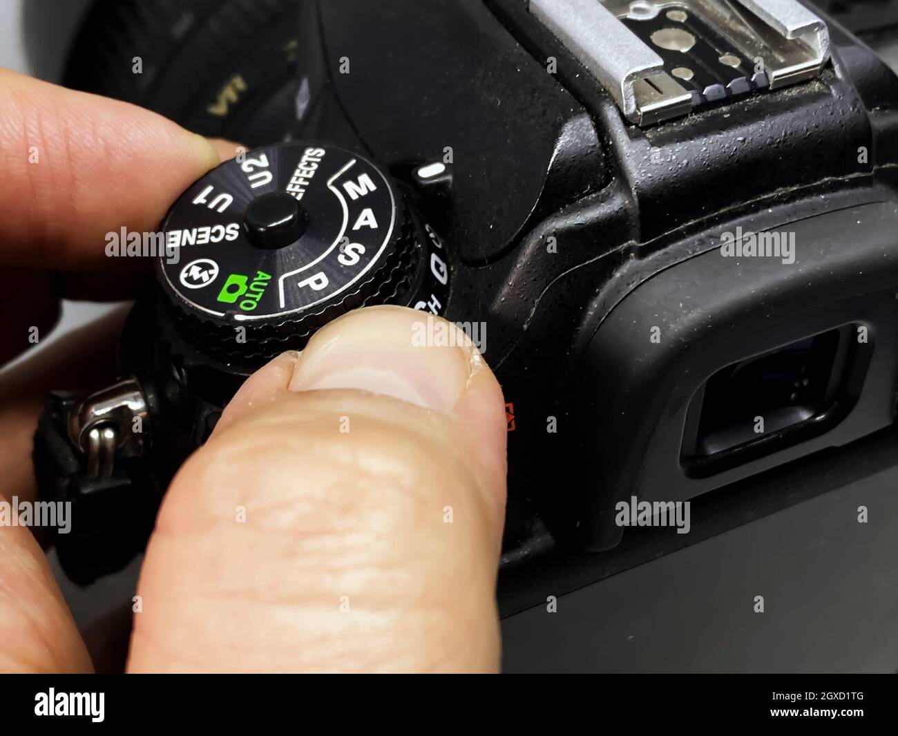 photographer turning the cogwheel to select the correct camera setting ...