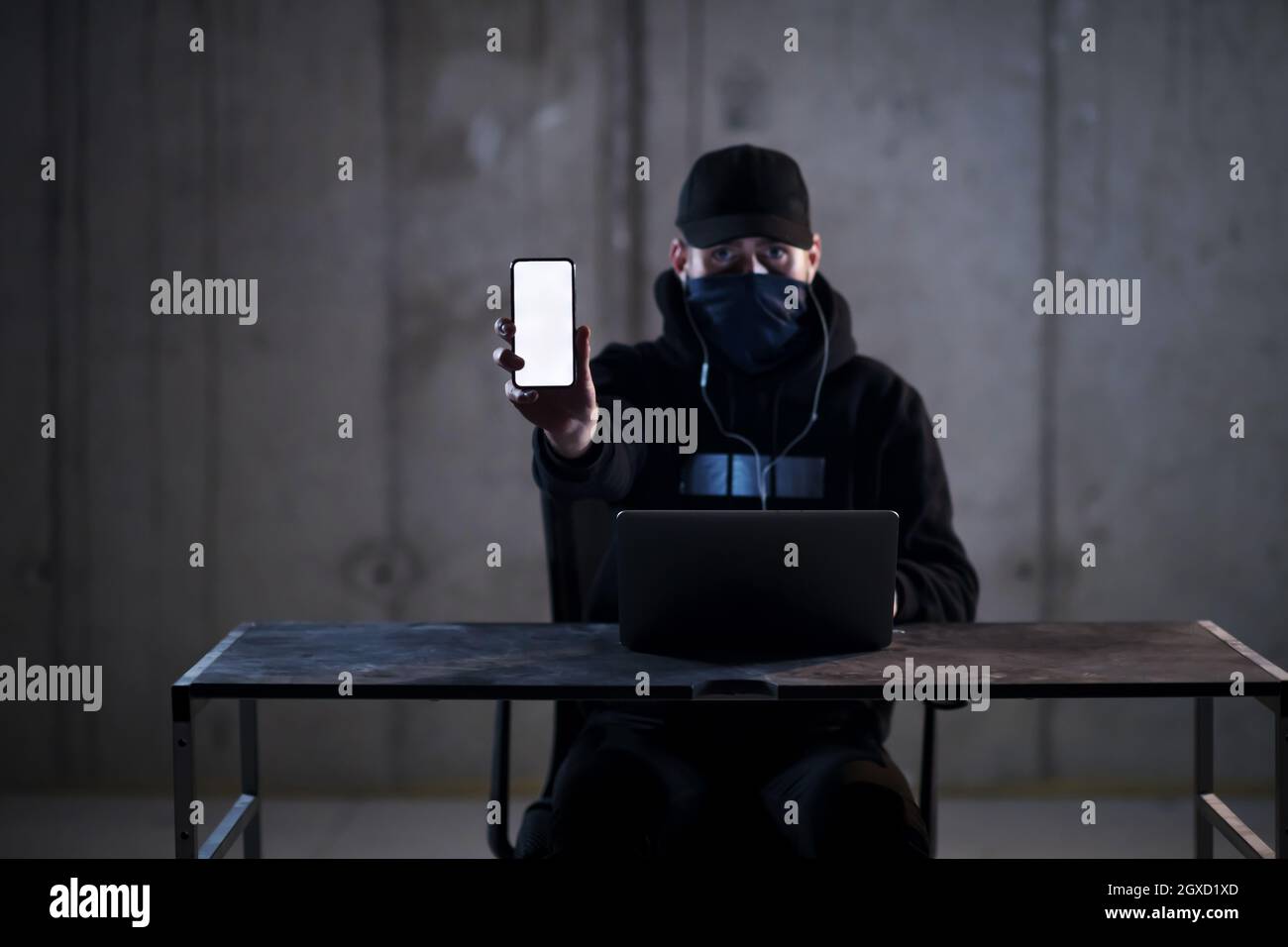 Young talented criminal hacker using laptop computer and showing the ...