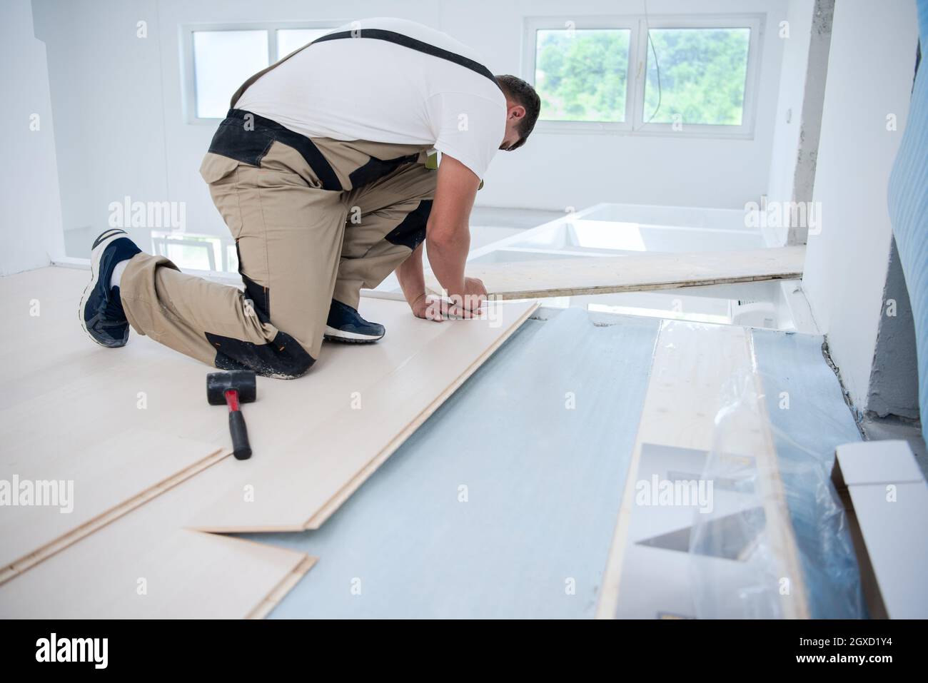 professional carpenter installing new laminated wooden floor in a ...