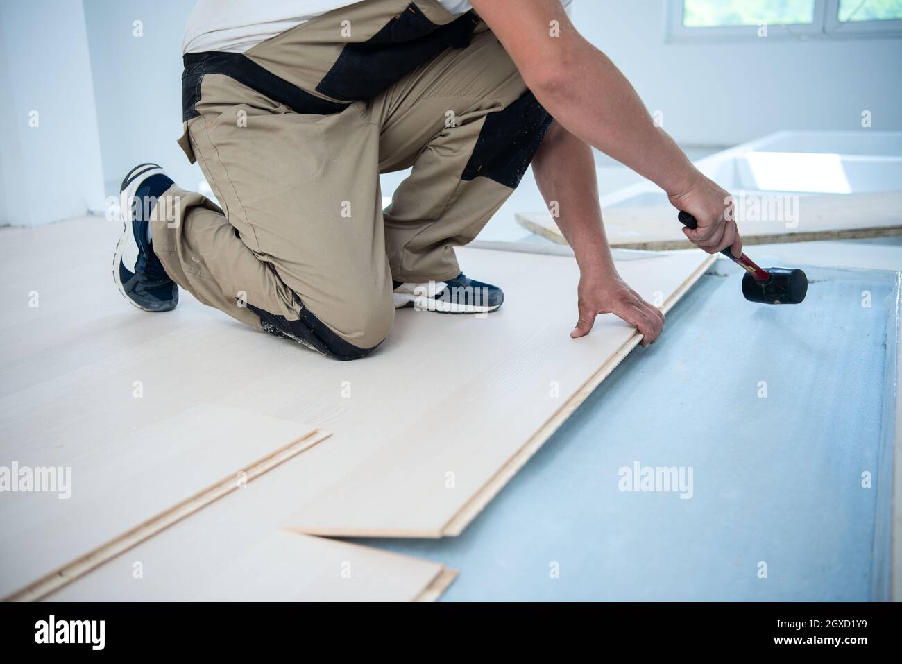 professional carpenter using rubber hammer while installing new ...