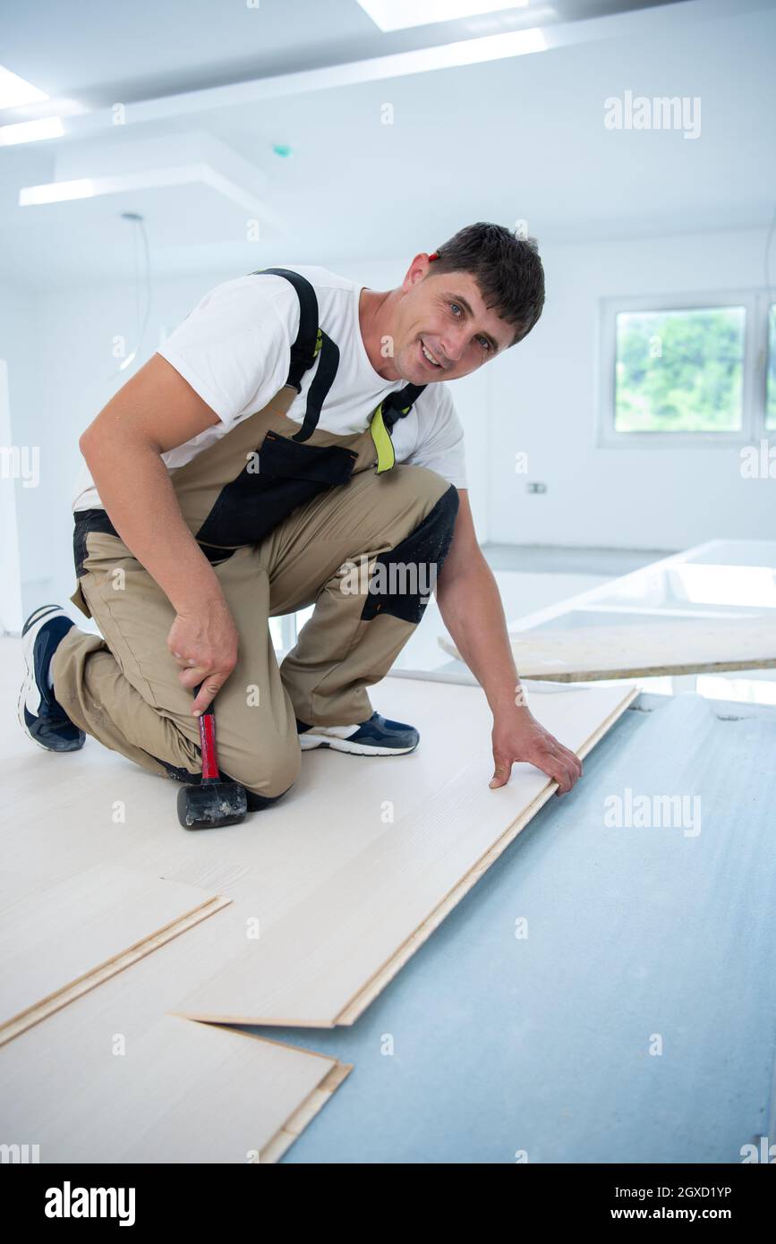 professional carpenter using rubber hammer while installing new ...