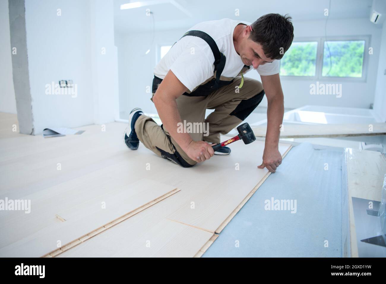 professional carpenter using rubber hammer while installing new ...
