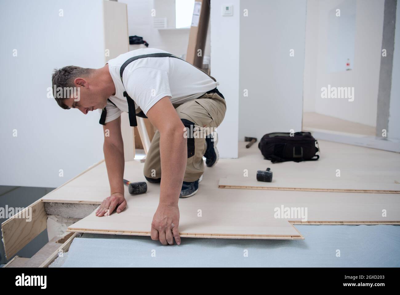 professional carpenter installing new laminated wooden floor in a ...