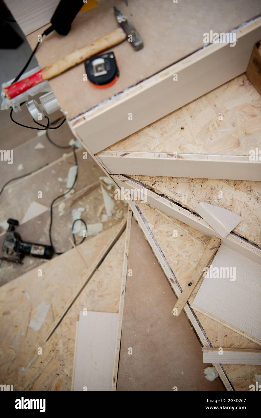 work in progress on stylish interior with wooden stairs in big modern ...