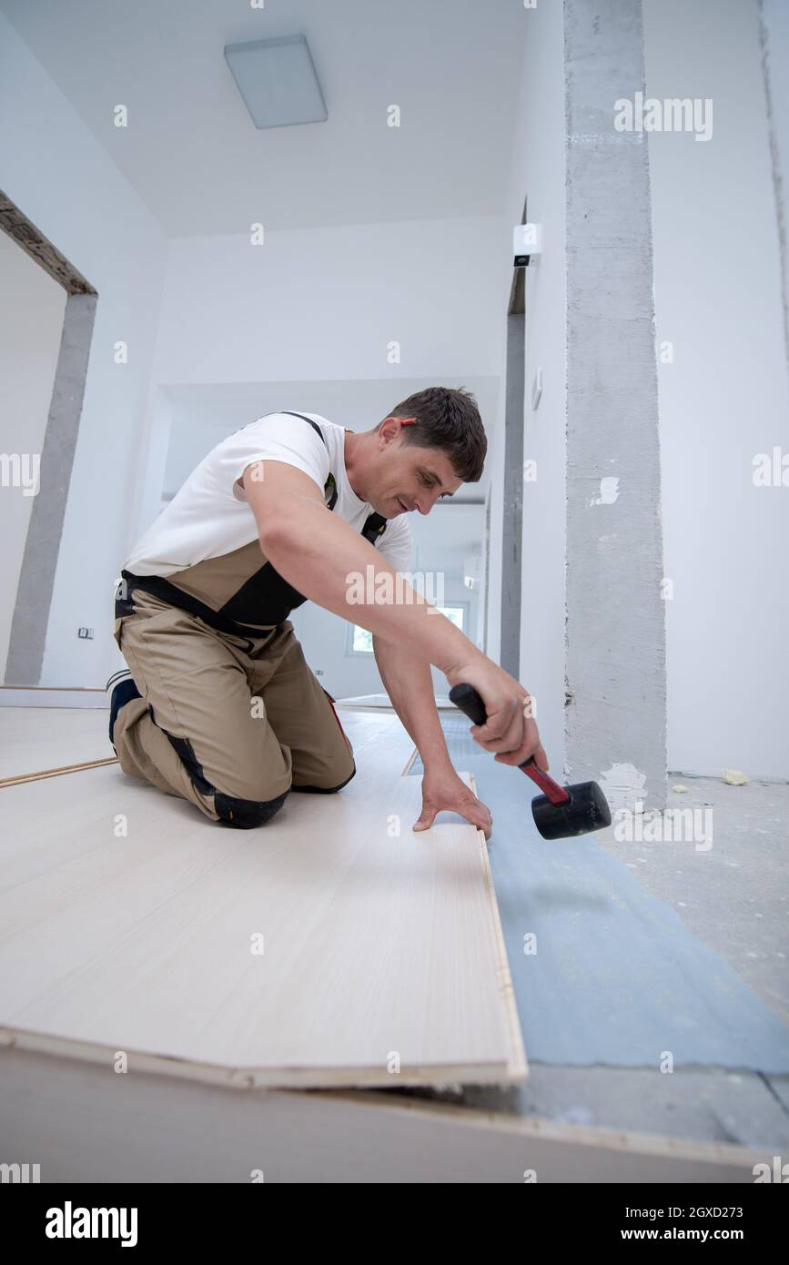 professional carpenter using rubber hammer while installing new ...