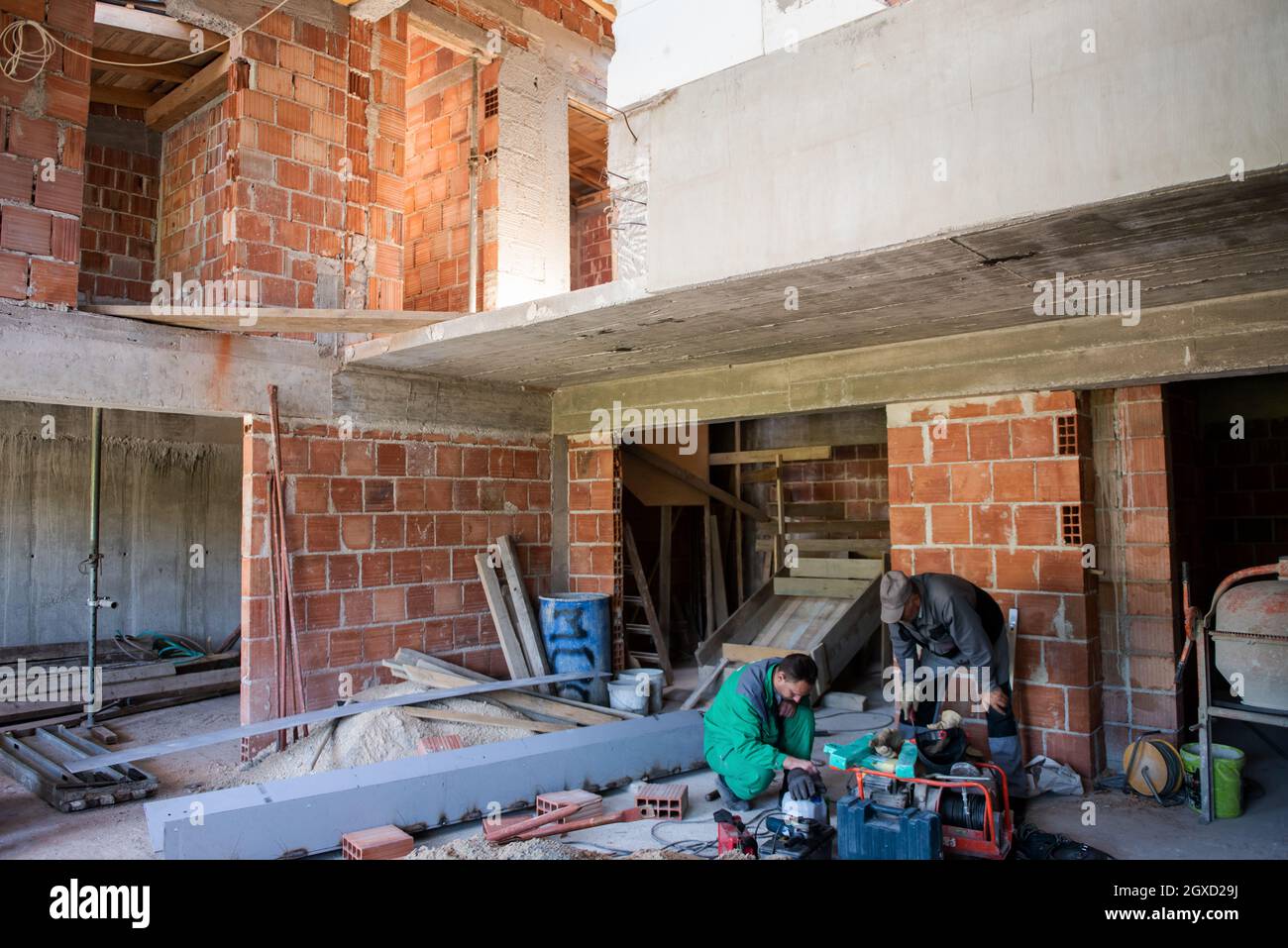 workers on construction site interior of new two levels apartment with ...
